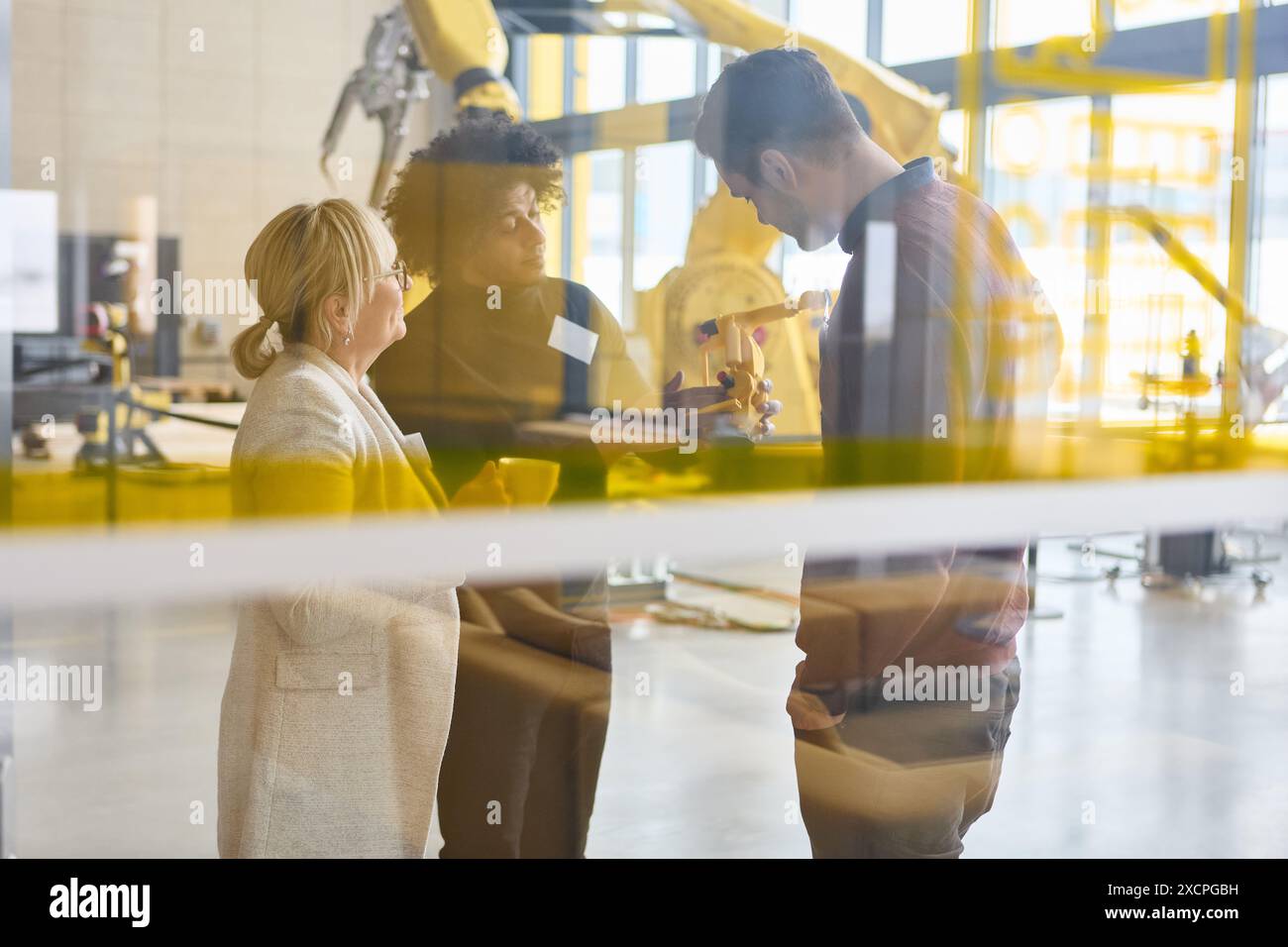 Group of engineers focused on robotics, automation, and programming in a modern industrial ...