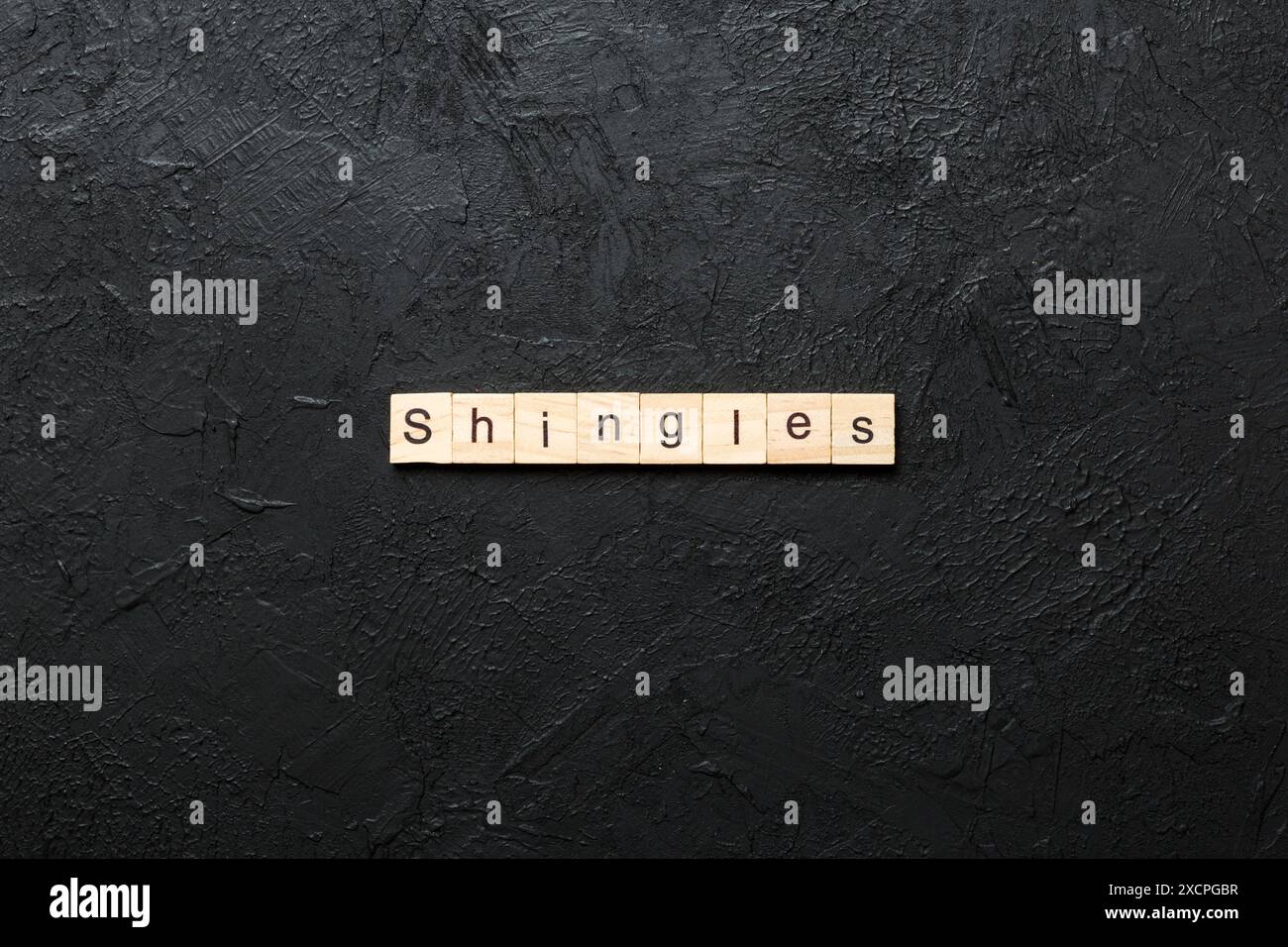Shingles word written on wood block. Shingles text on cement table for ...