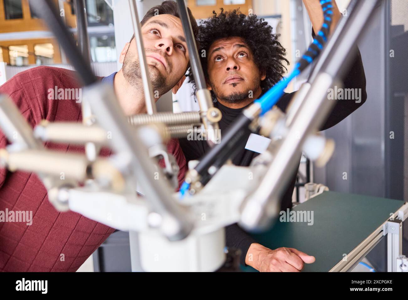 Two Engineers Collaborating On Programming A Robotic Arm For Industrial Automation And