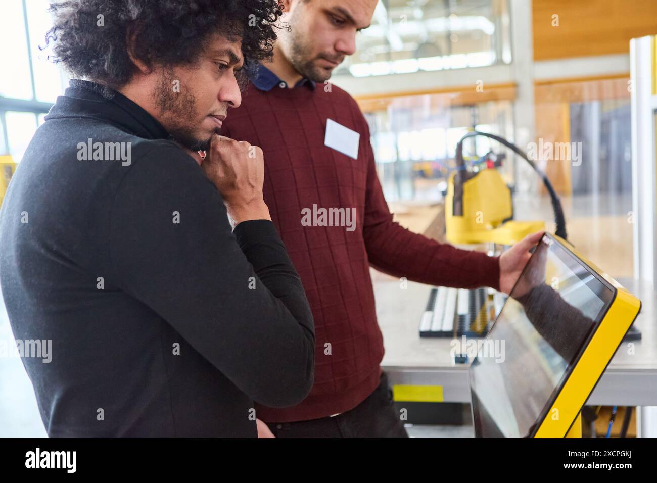 Two engineers focused on programming a robotic arm in a modern ...