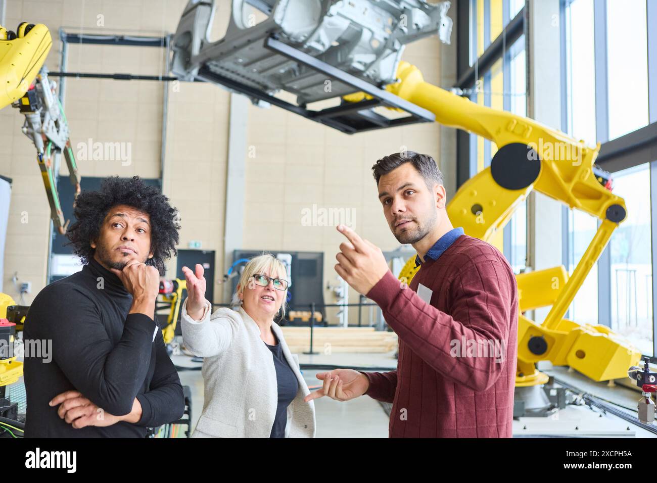A diverse team engages in discussion about robotics and automation ...