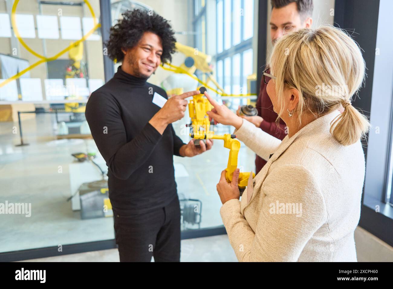Group of engineers engaging in a discussion about robotics design and programming in a modern ...