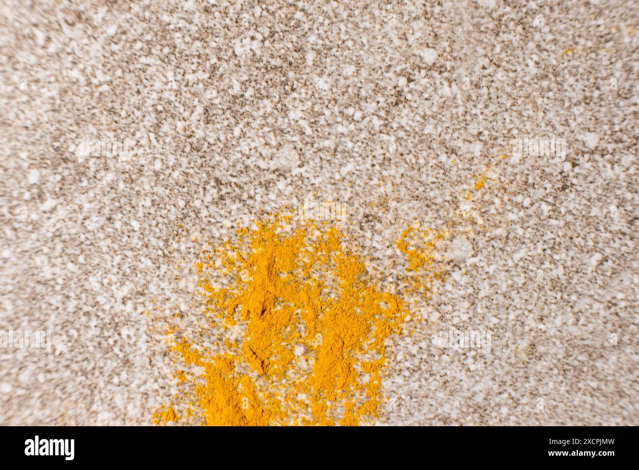 Scattered turmeric powder on gray stone background, turmeric pattern ...
