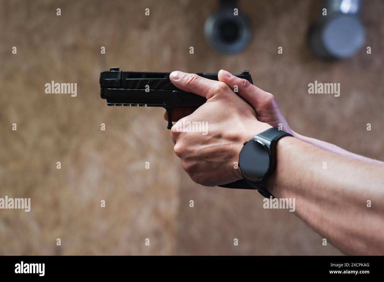 Aiming from a modern pistol at a shooting range, weapons in male hands ...