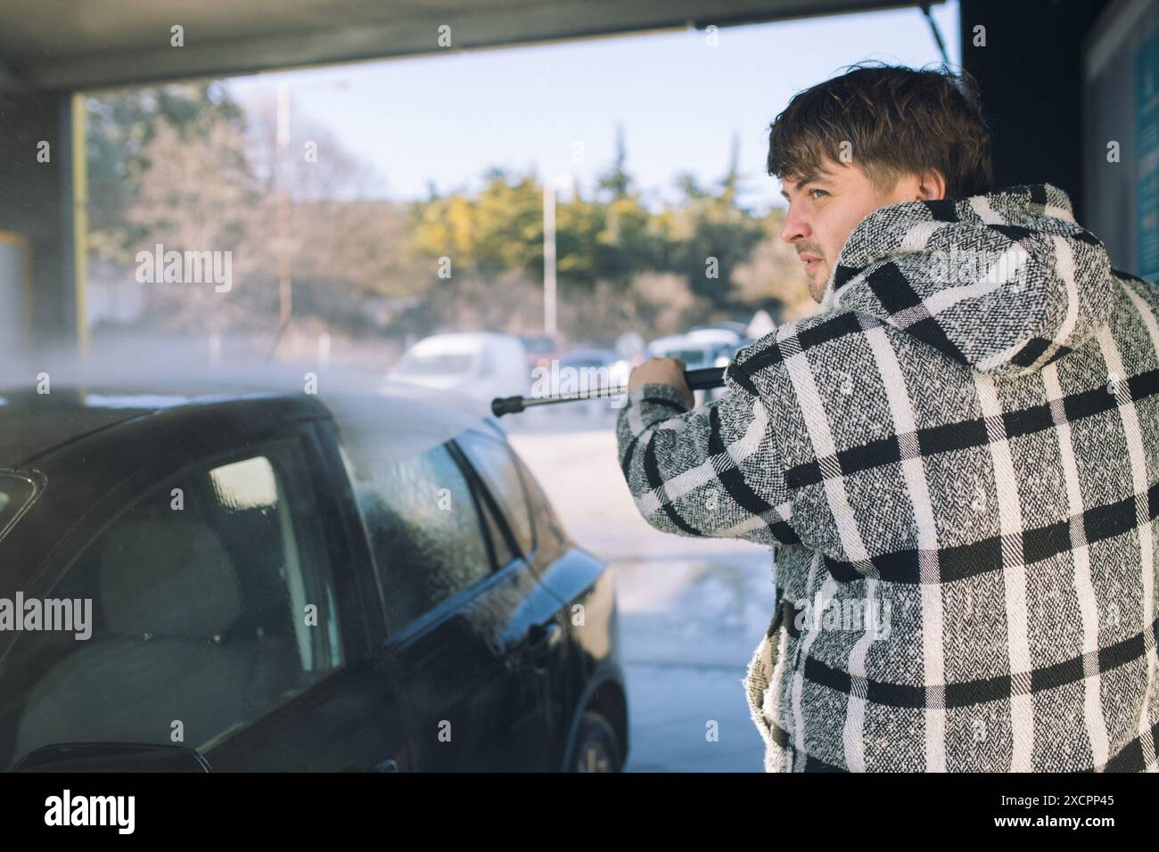 Cleaning car using active foam. Man washing his car on self car-washing ...