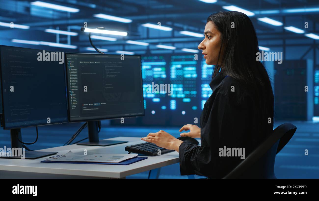 Technician working in high tech server room, analyzing data on multiple ... Technician working in high tech server room, analyzing data on multiple ...
