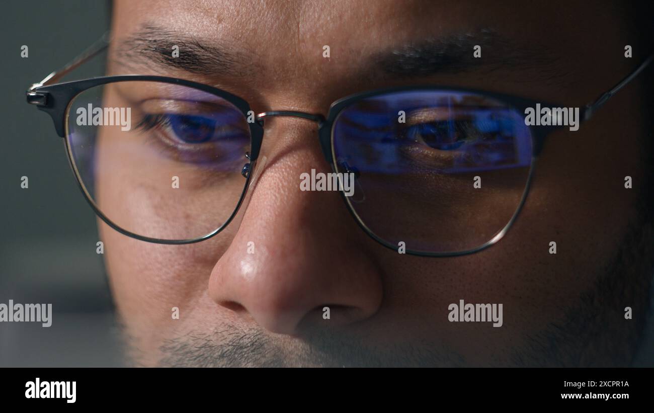 Close up male eyes in eyeglasses laptop monitor light programming ...