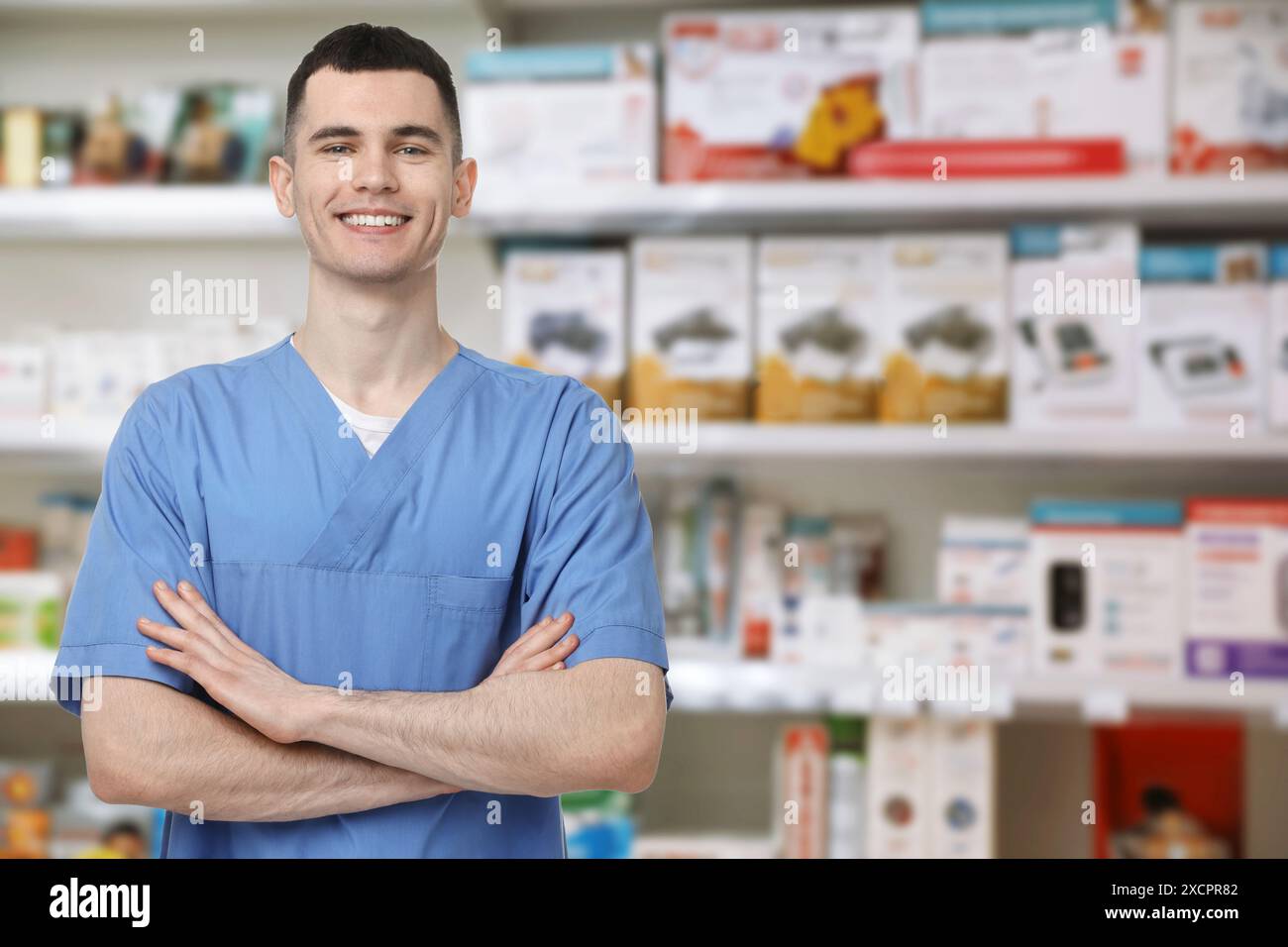 Positive pharmacist in uniform at drugstore. Space for text Stock Photo ...