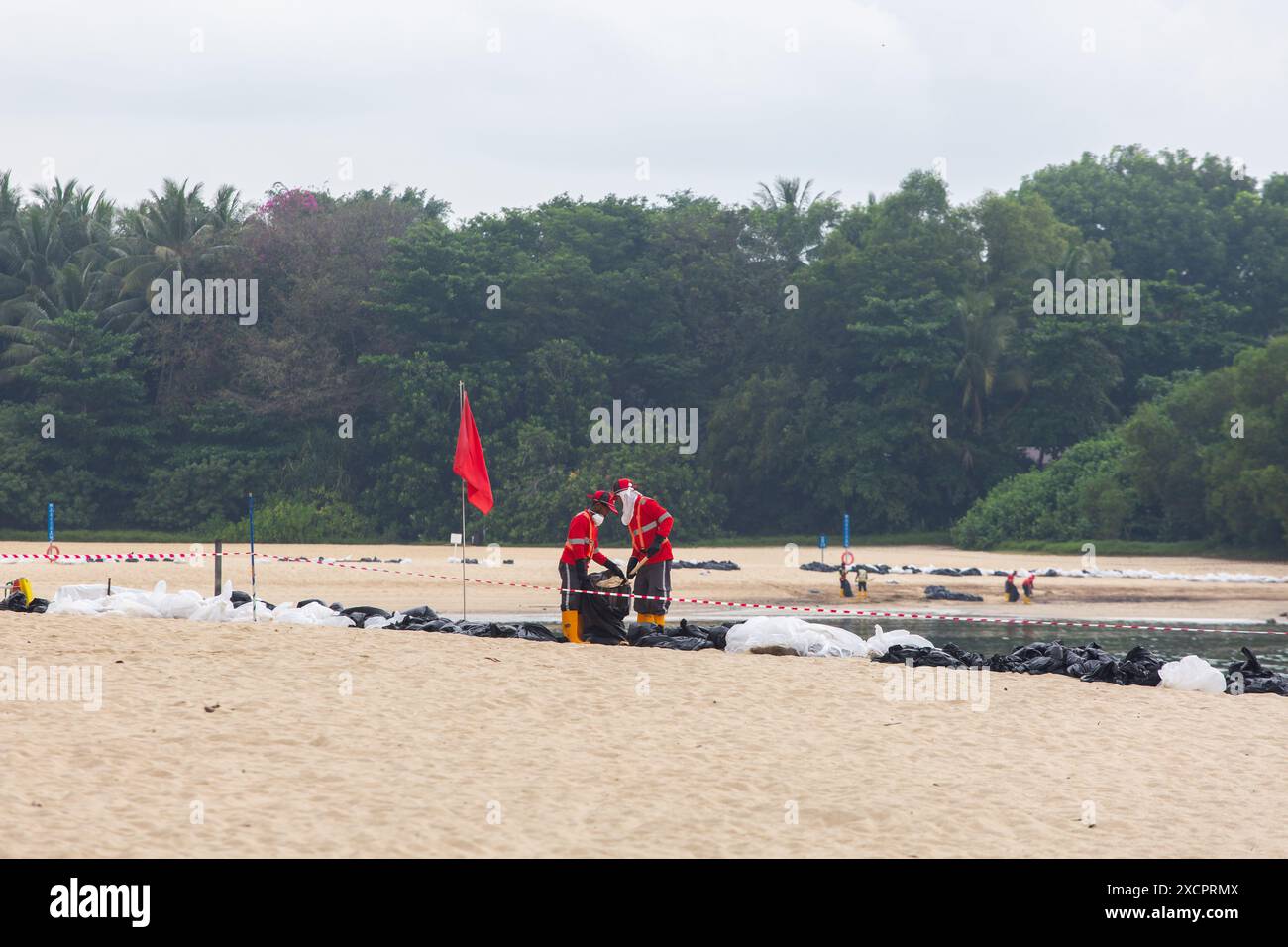 Workers are cleaning up oil spills along Palawan Beach coastline. A ...