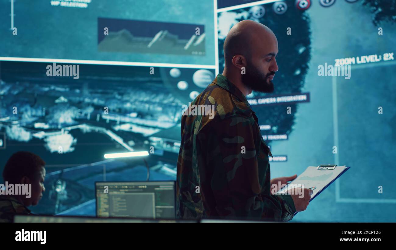 Army officer examining real time satellite data on big screen in ...