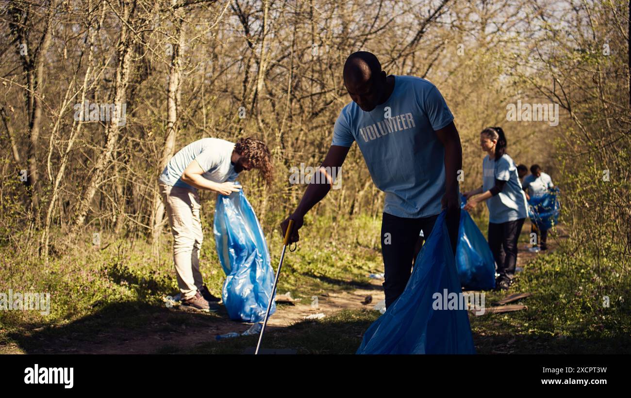 African american man volunteer collecting trash and plastic waste with ...
