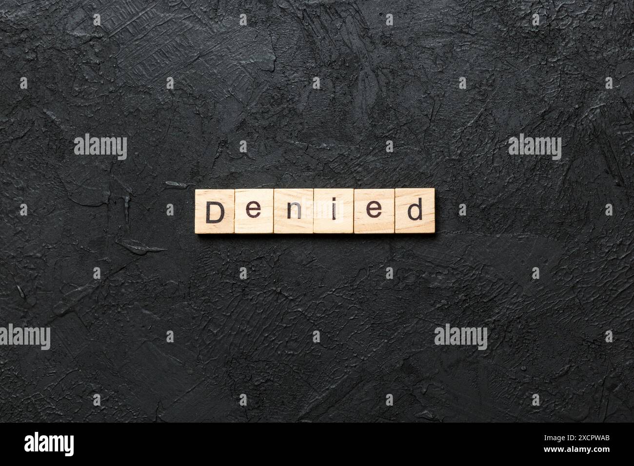 DENIED word written on wood block. DENIED text on cement table for your ...