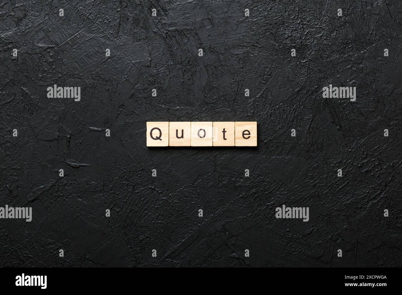 Quote word written on wood block. Quote text on cement table for your ...
