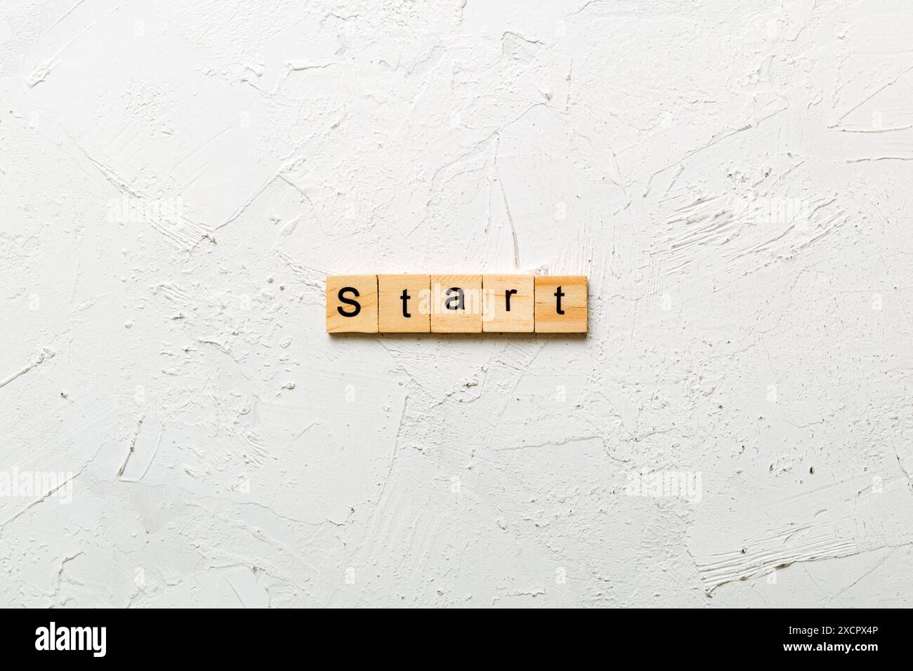 Start word written on wood block. Start text on cement table for your ...
