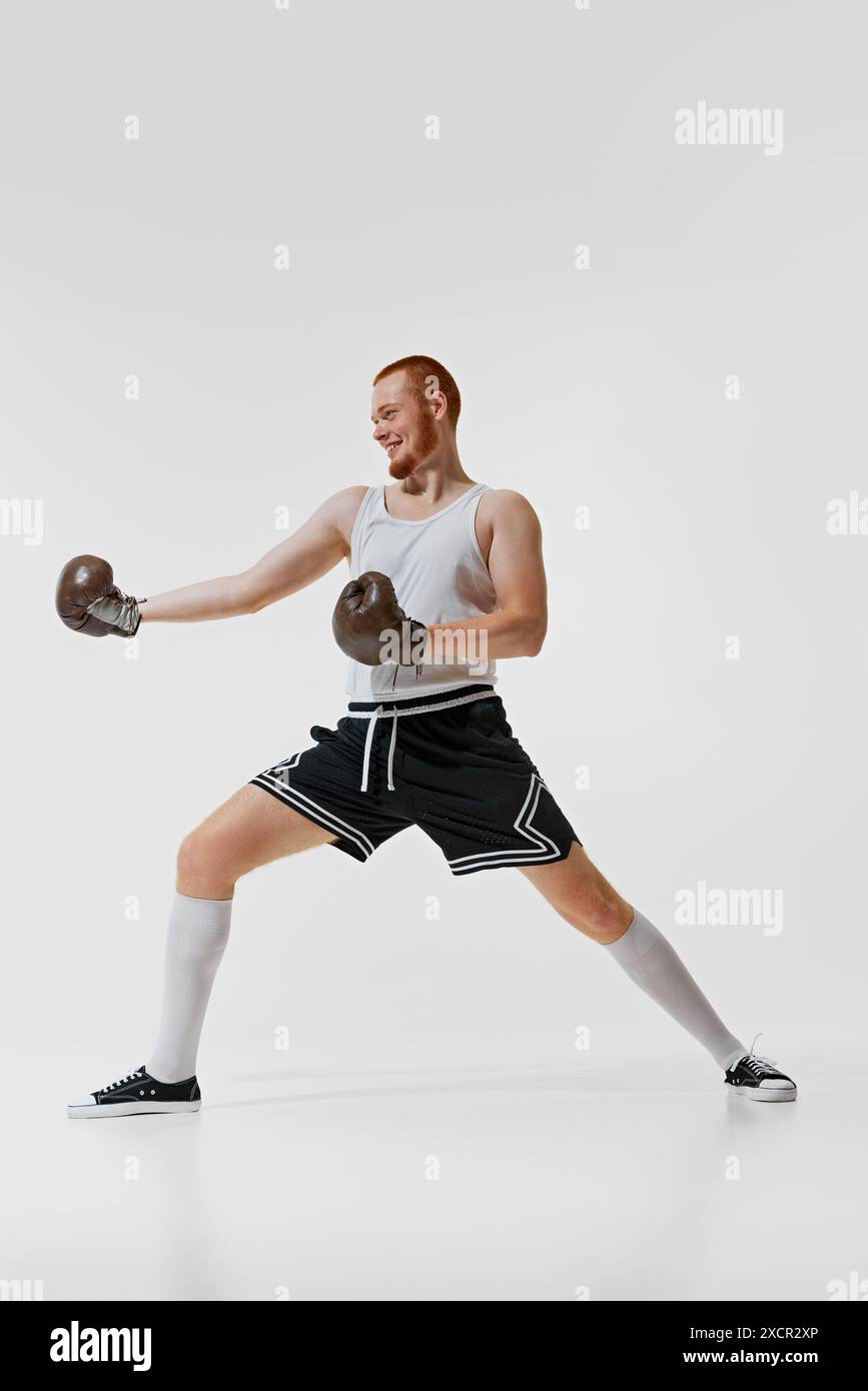 Full-length image of competitive smiling young guy in casual clothes ...