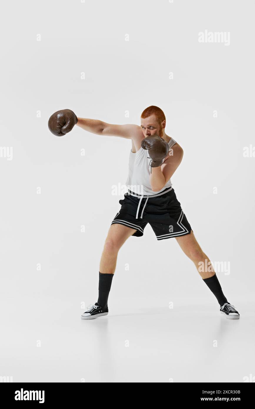 Pinching and defensive stance. Young guy in vintage brown boxing gloves ...
