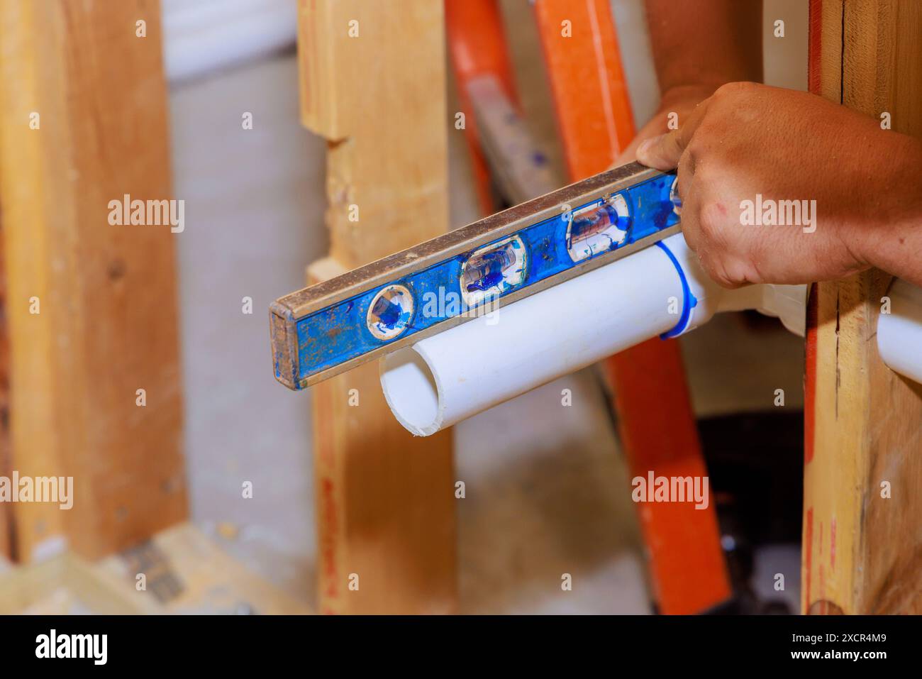 During gluing process, sanitary plastic PVC pipes are leveled using ...