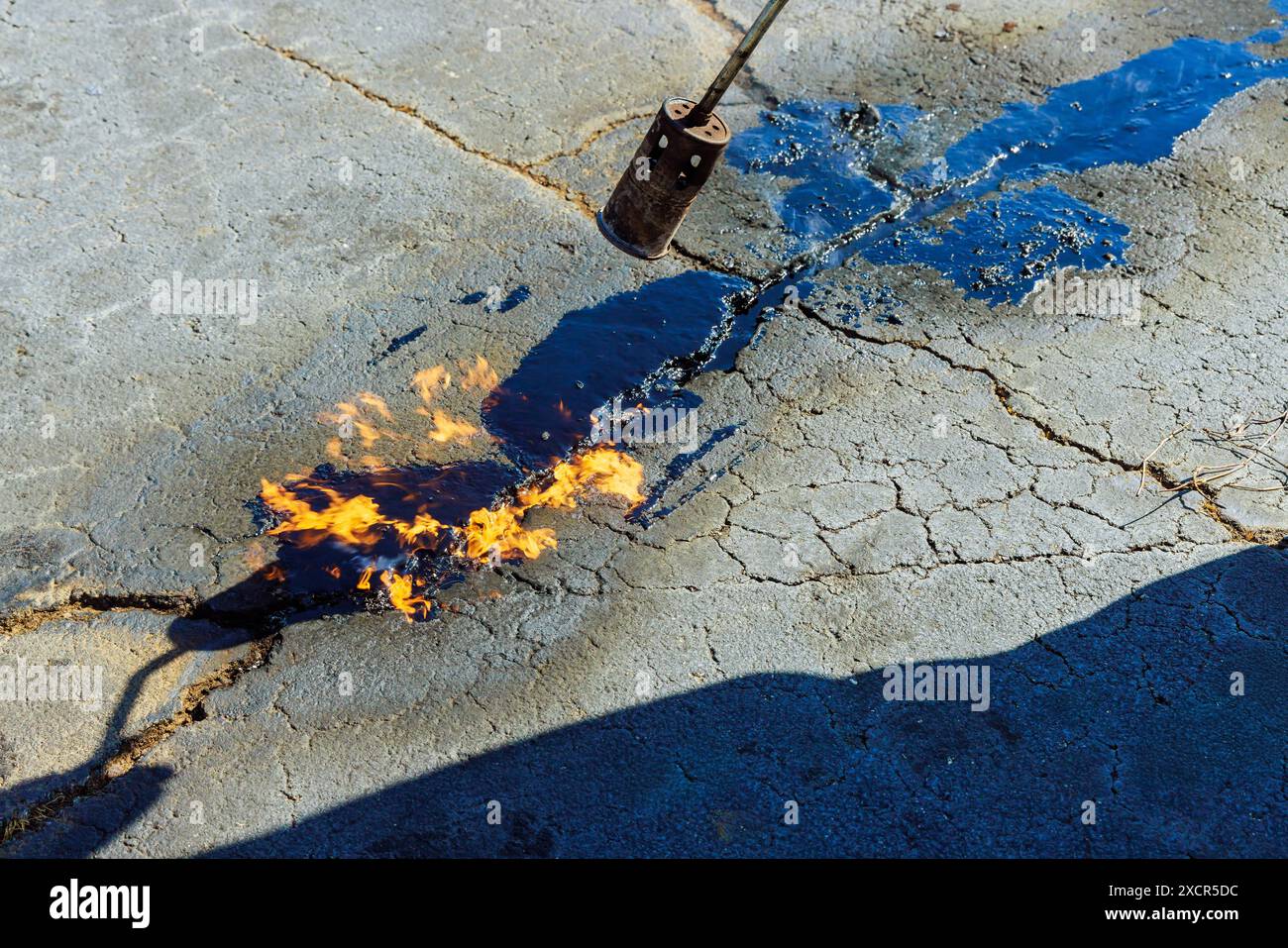 Asphalt cracks are heated before they are filled with hot bitumen ...