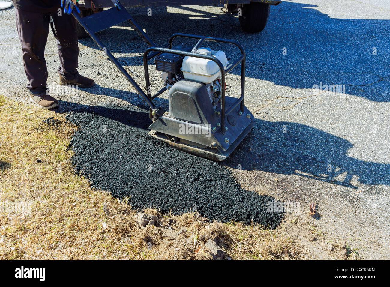 Using tamping compacting vibratory to tamp asphalt in parking lot Stock ...