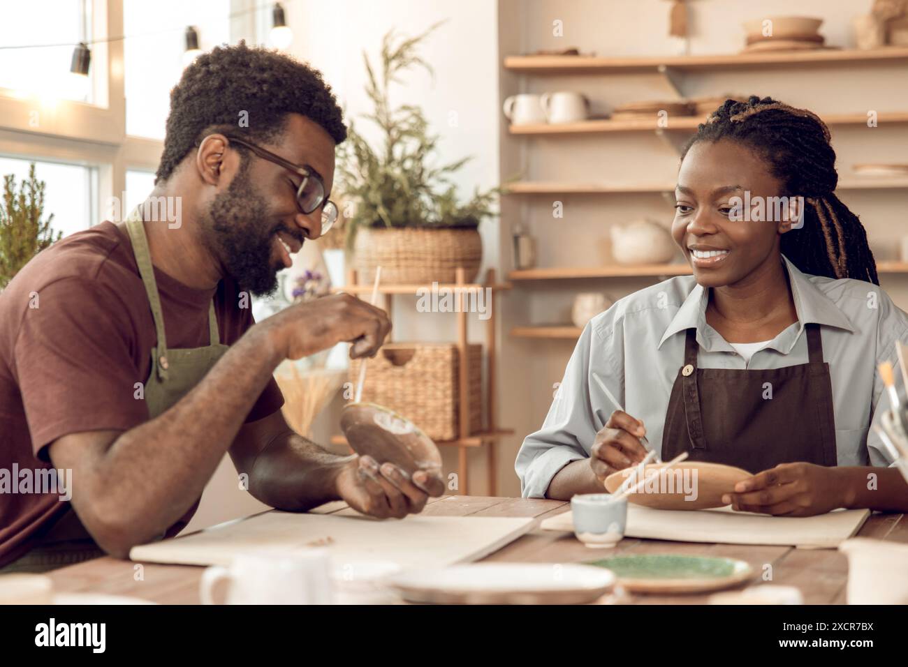 African american male sculptor explaining something to a female student ...