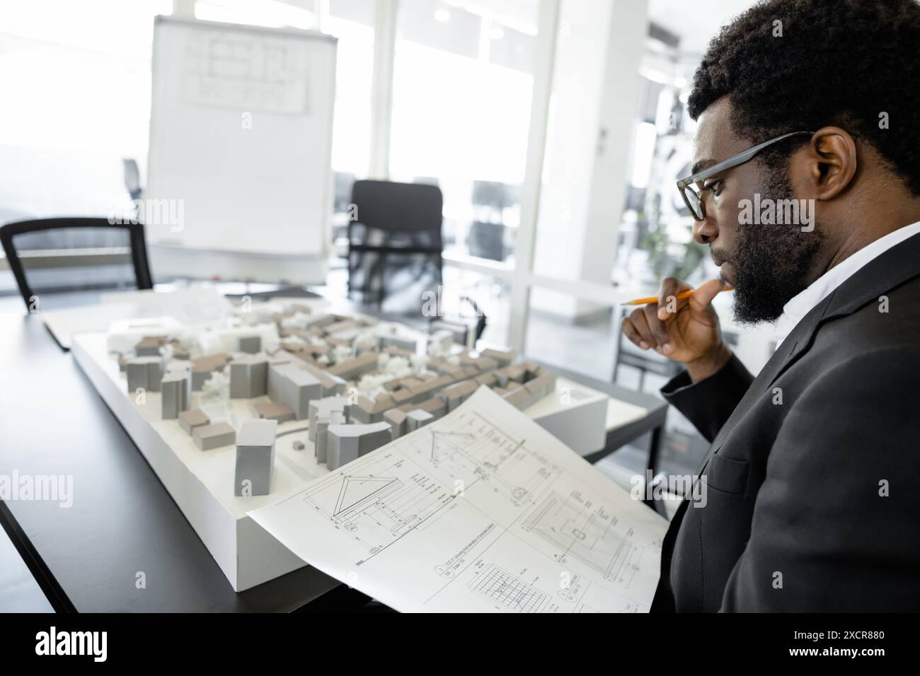 Skillful man architect working with blueprints in the office Stock ...