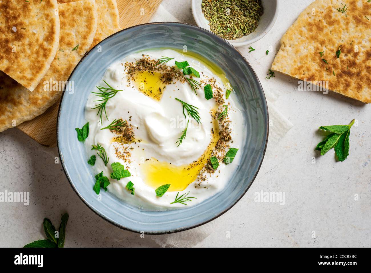 Labneh yogurt cream cheese with olive oil, herbs and zaatar close up ...