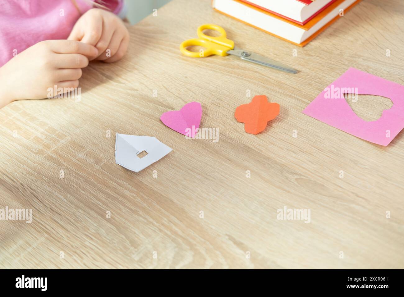 preschooler girl practicing scissor skills by cutting out shapes such ...