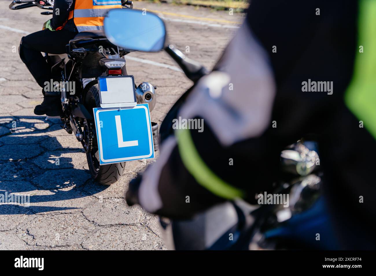 A man is riding a motorcycle with a blue plate with letter L Stock ...