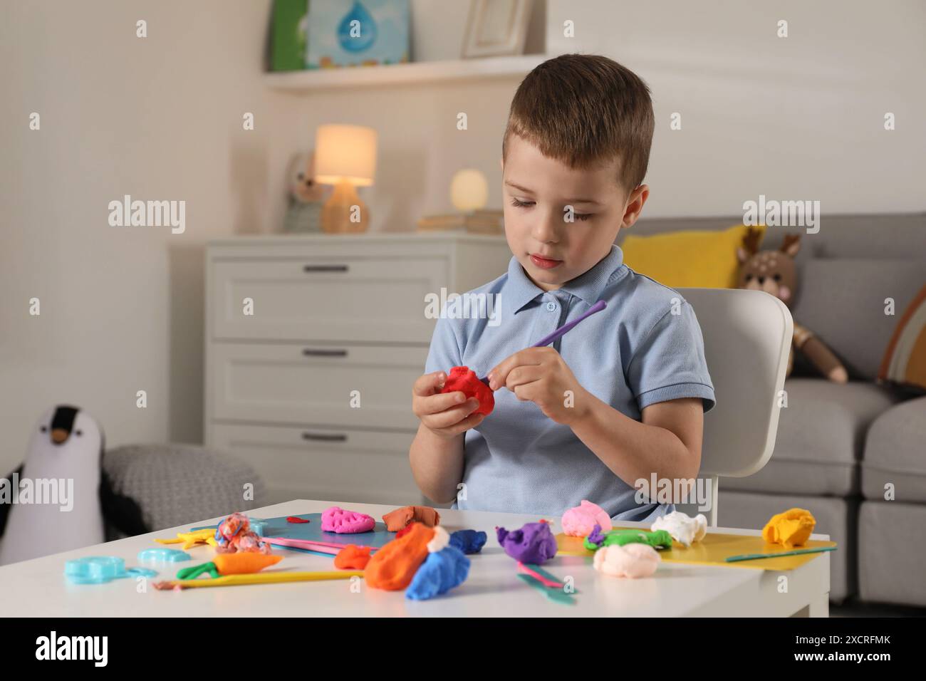 Little boy sculpting with play dough at table indoors Stock Photo - Alamy