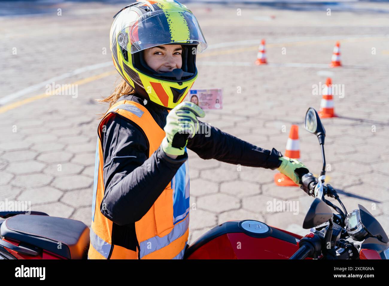 Student showing motorcycle driving license as successfully finished ...