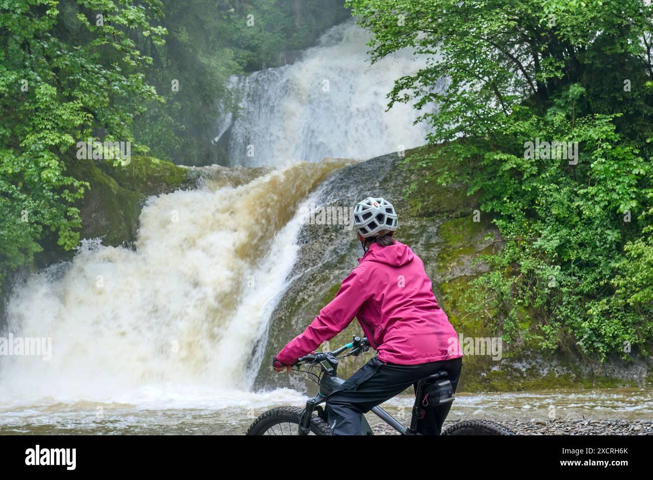 senior woman, riding her electric mountain bike and watching the Eibele ...