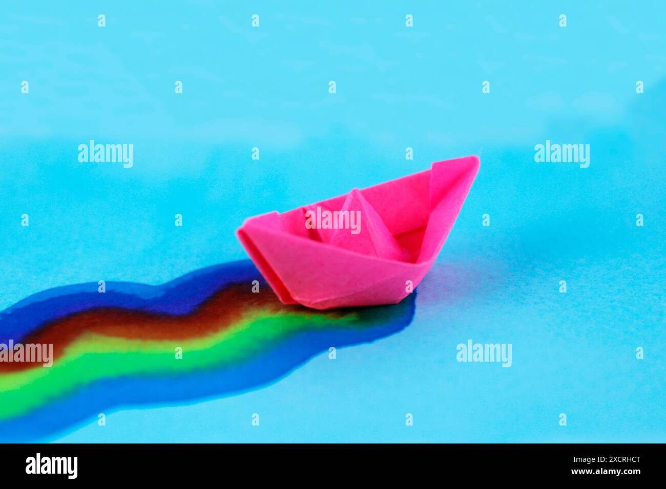 Pink boat leaving a wake with the colors of the rainbow Stock Photo - Alamy
