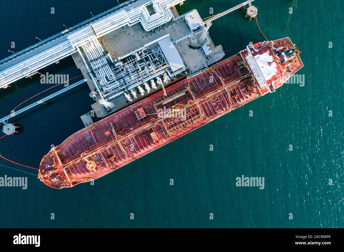 Aerial top down view of a large oil tanker docked at a pier in the port ...