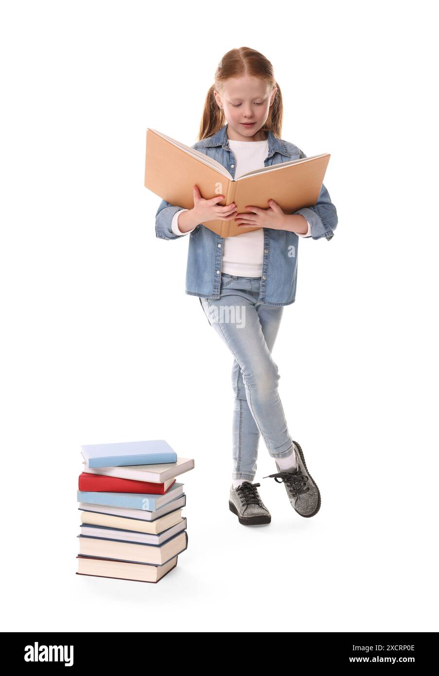 Cute girl reading near stack of books on white background Stock Photo ...