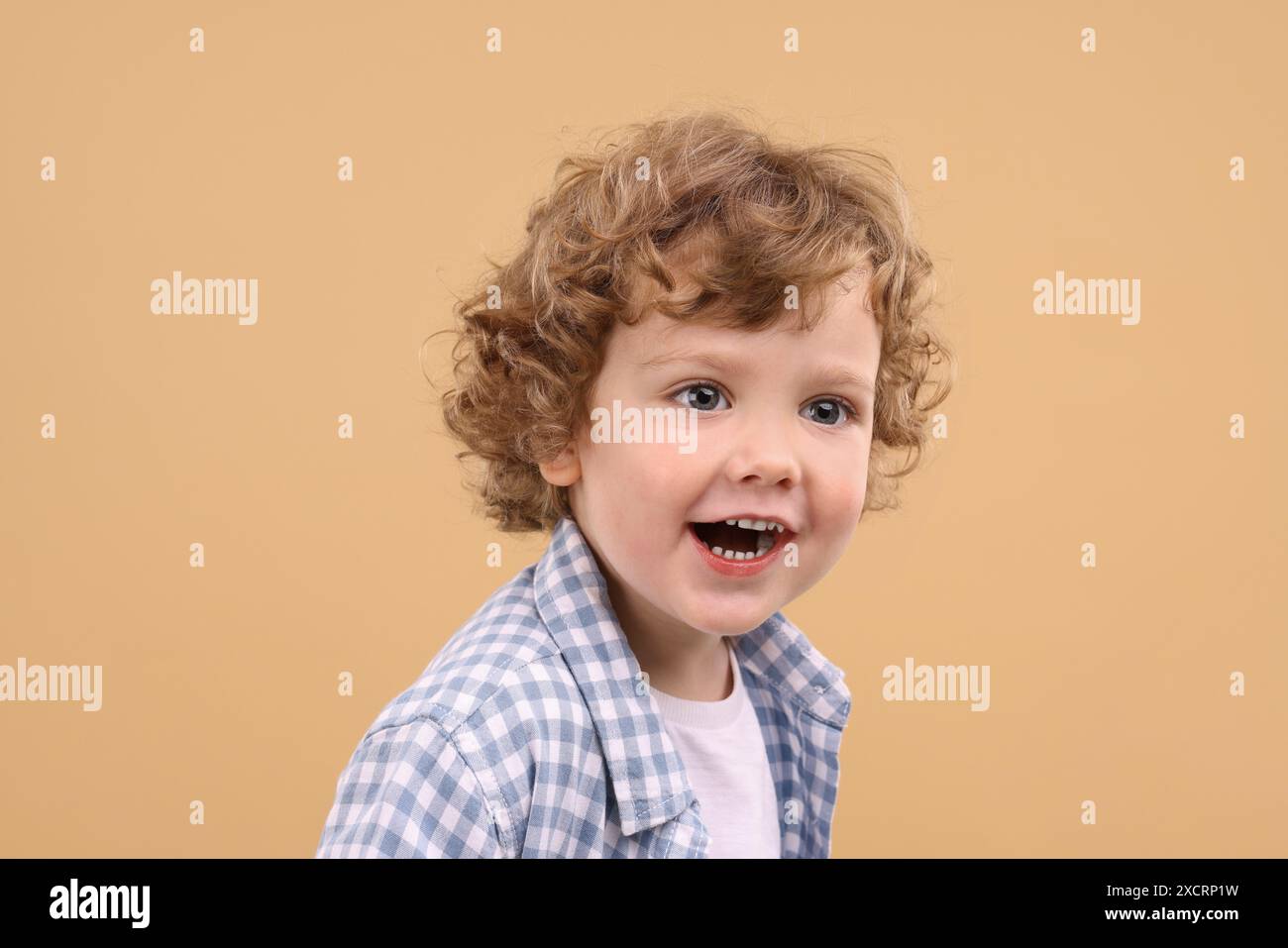 Portrait of cute little boy on beige background Stock Photo - Alamy