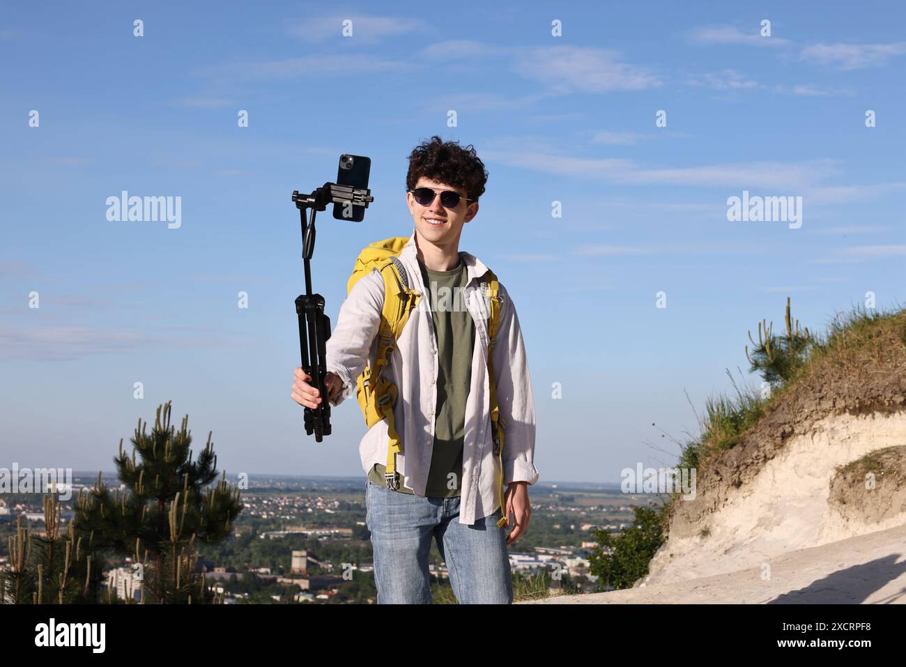 Travel blogger in sunglasses with smartphone streaming outdoors Stock ...