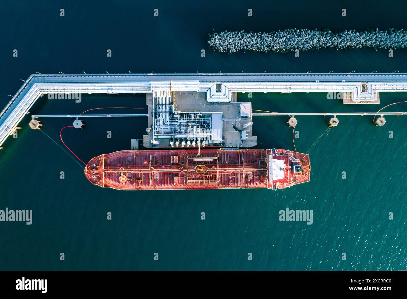 Aerial top down view of a large oil tanker docked at a pier in the port ...