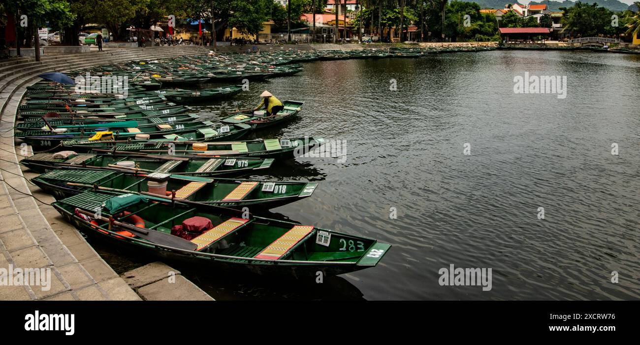 Tourist Sampans lined up along the marvellously tranquilTam Coc river ...