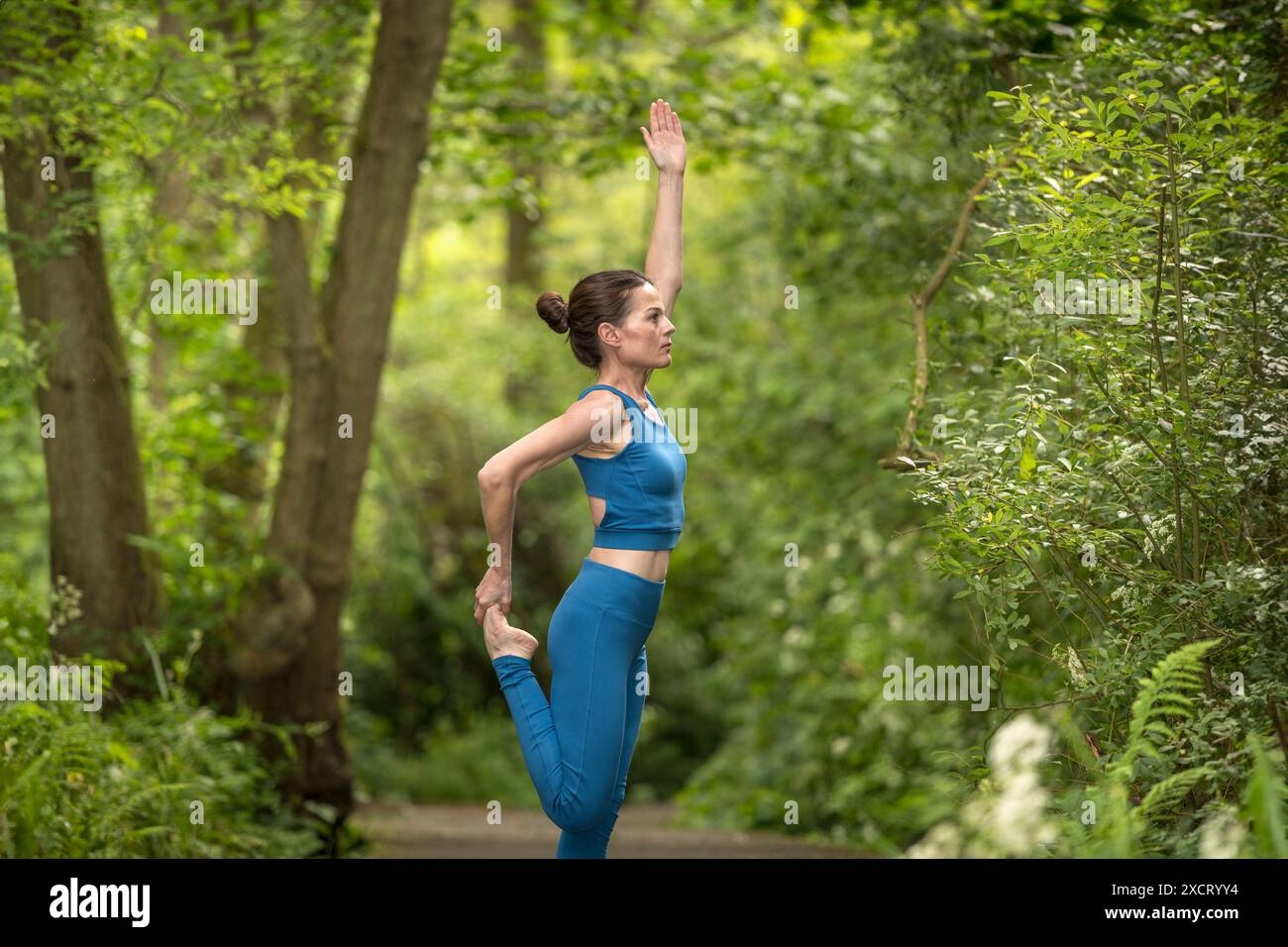 Sporty woman runner doing leg stretching exercises outside in the park ...