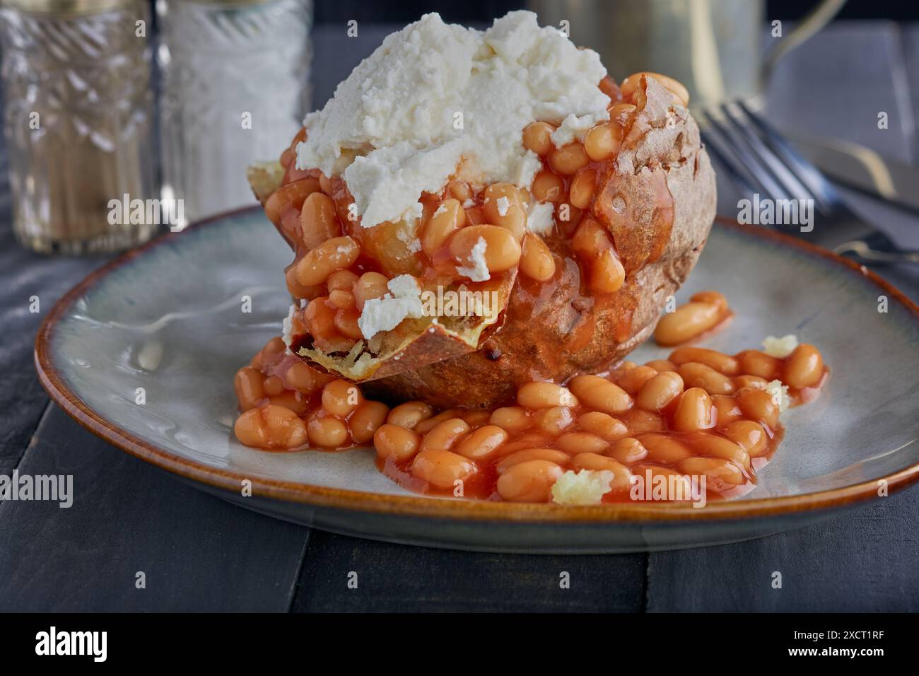 Baked jacket potato filled with baked beans and ricotta cheese Stock ...