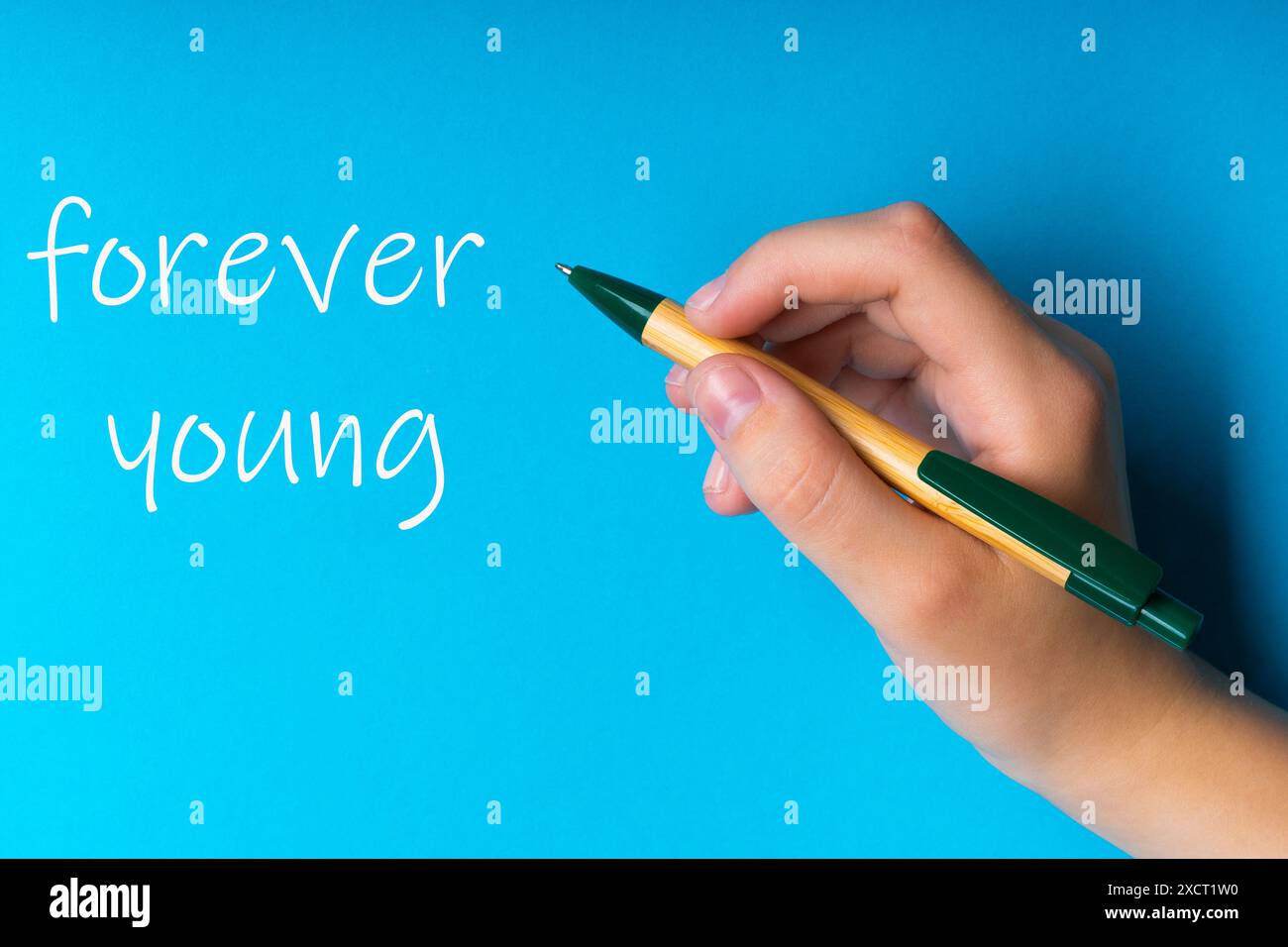 Children hand with pen write on an blue white background. Writing hand ...