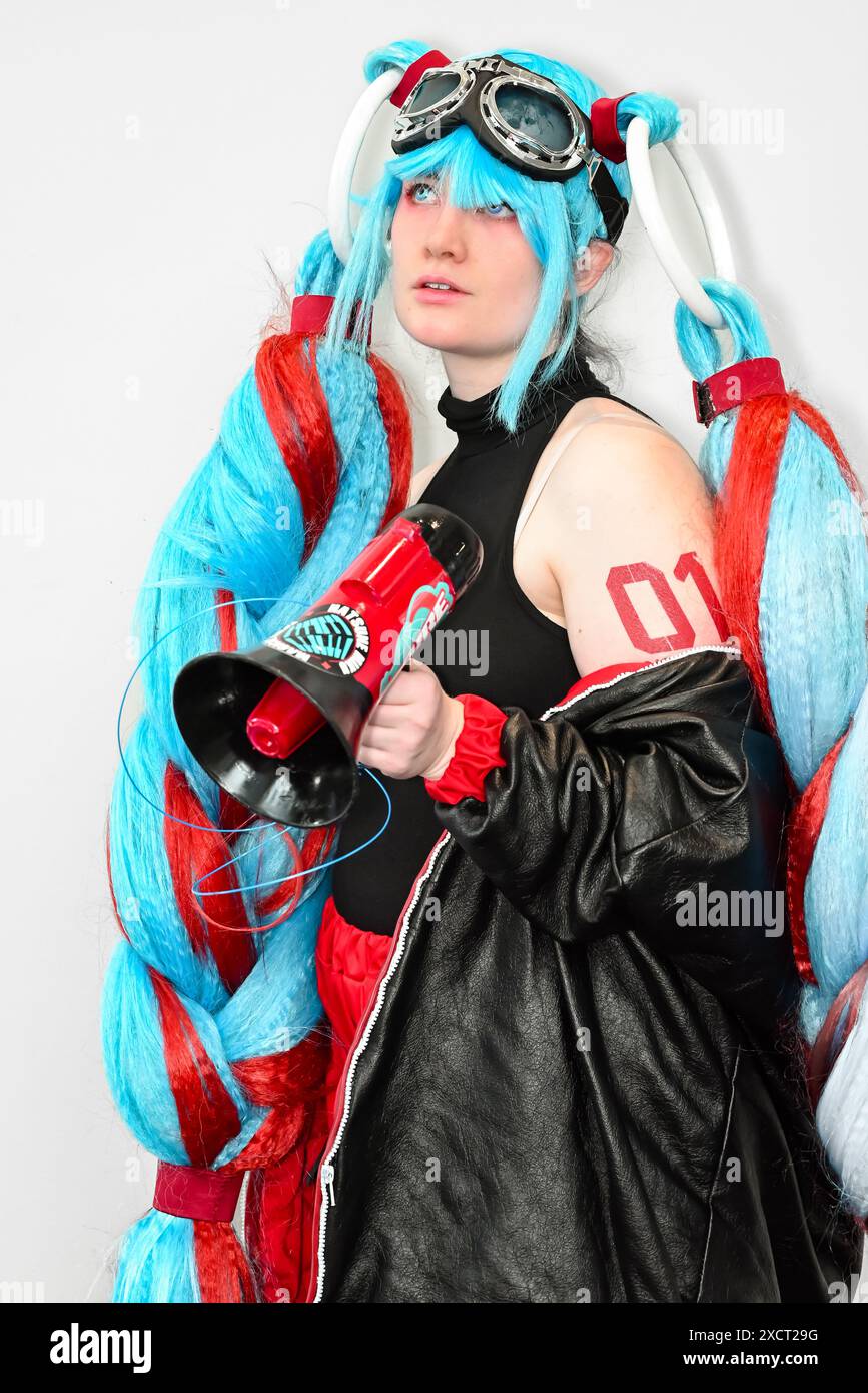 A female cosplayer dressed as an anime character with blue hair and a ...
