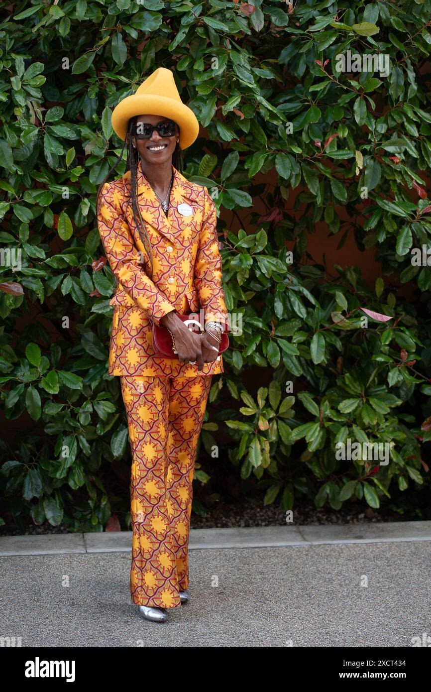 A lady wears a vibrant orange and yellow trouser suit to day one of ...