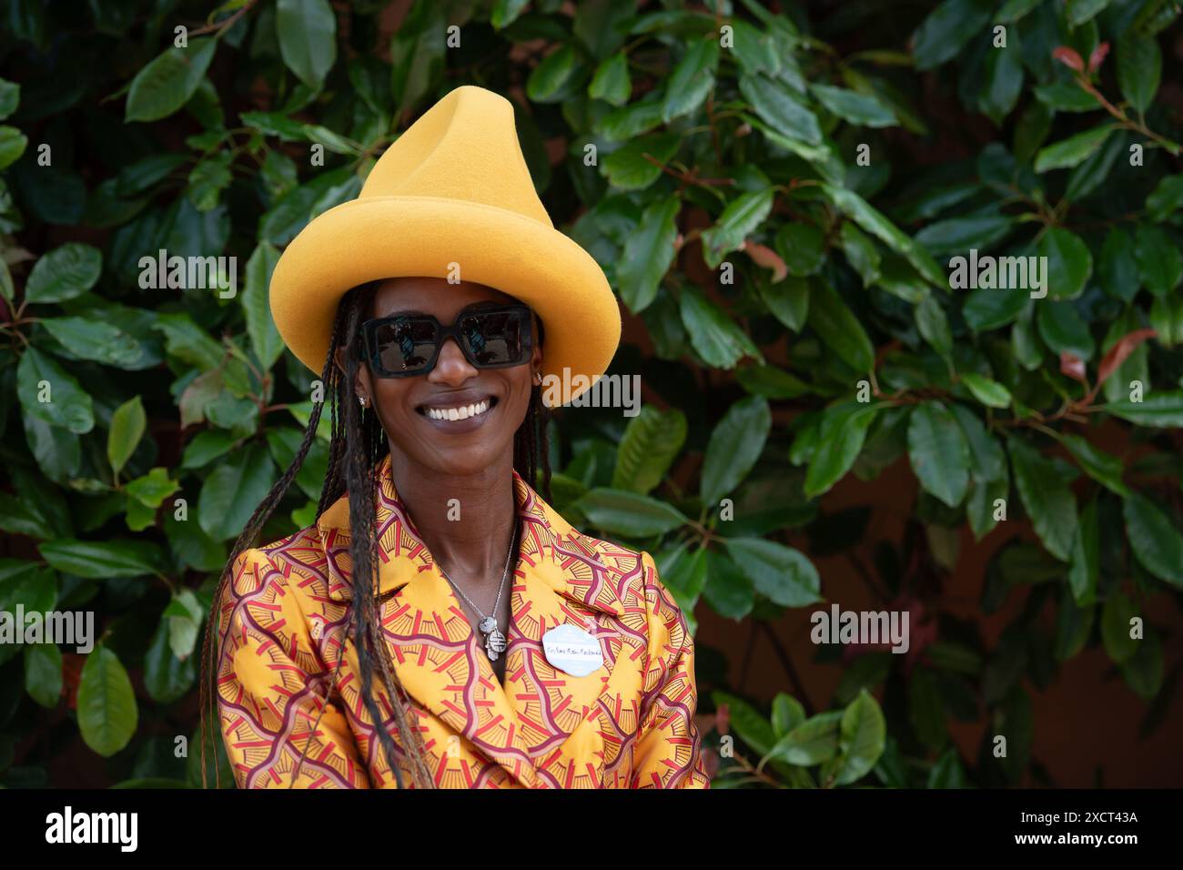 A lady wears a vibrant orange and yellow trouser suit to day one of ...