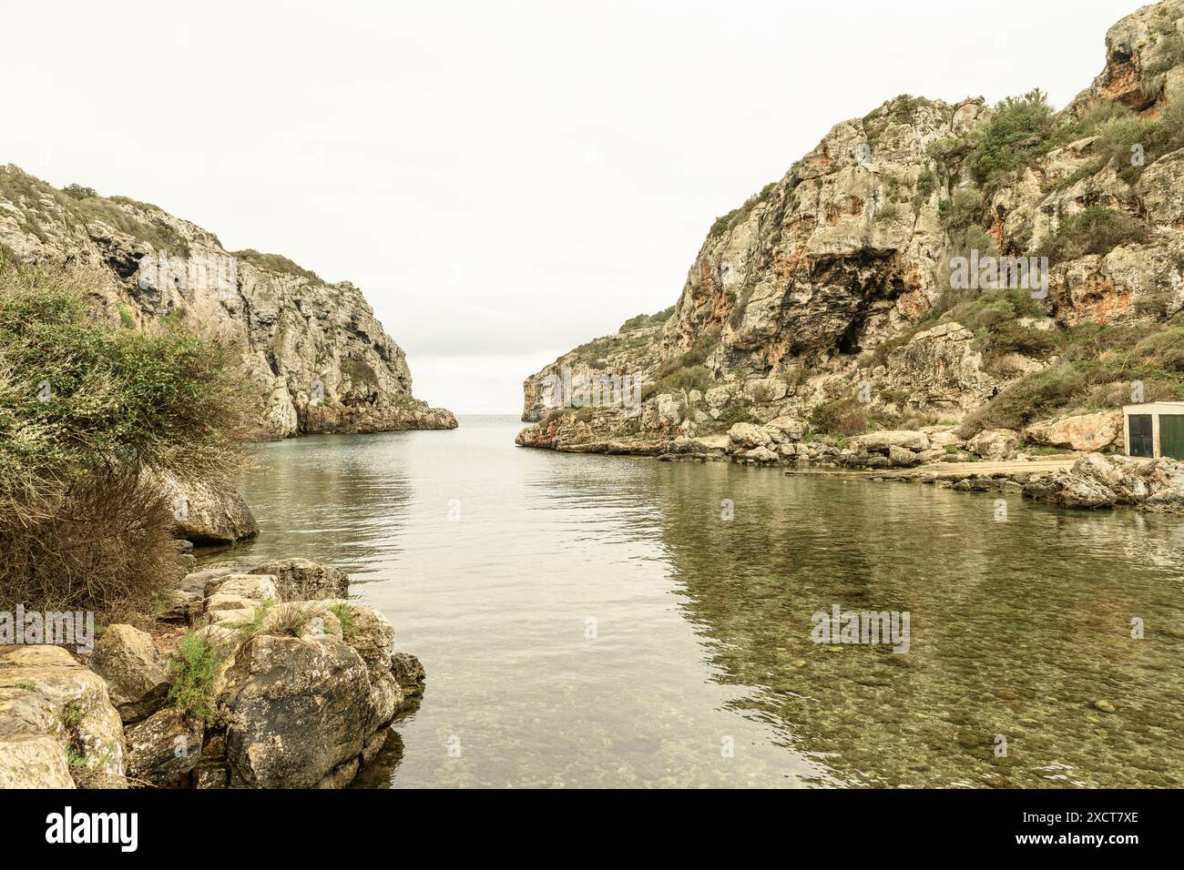 A rugged, rocky inlet at Cala Coves, Menorca, showcasing dramatic ...