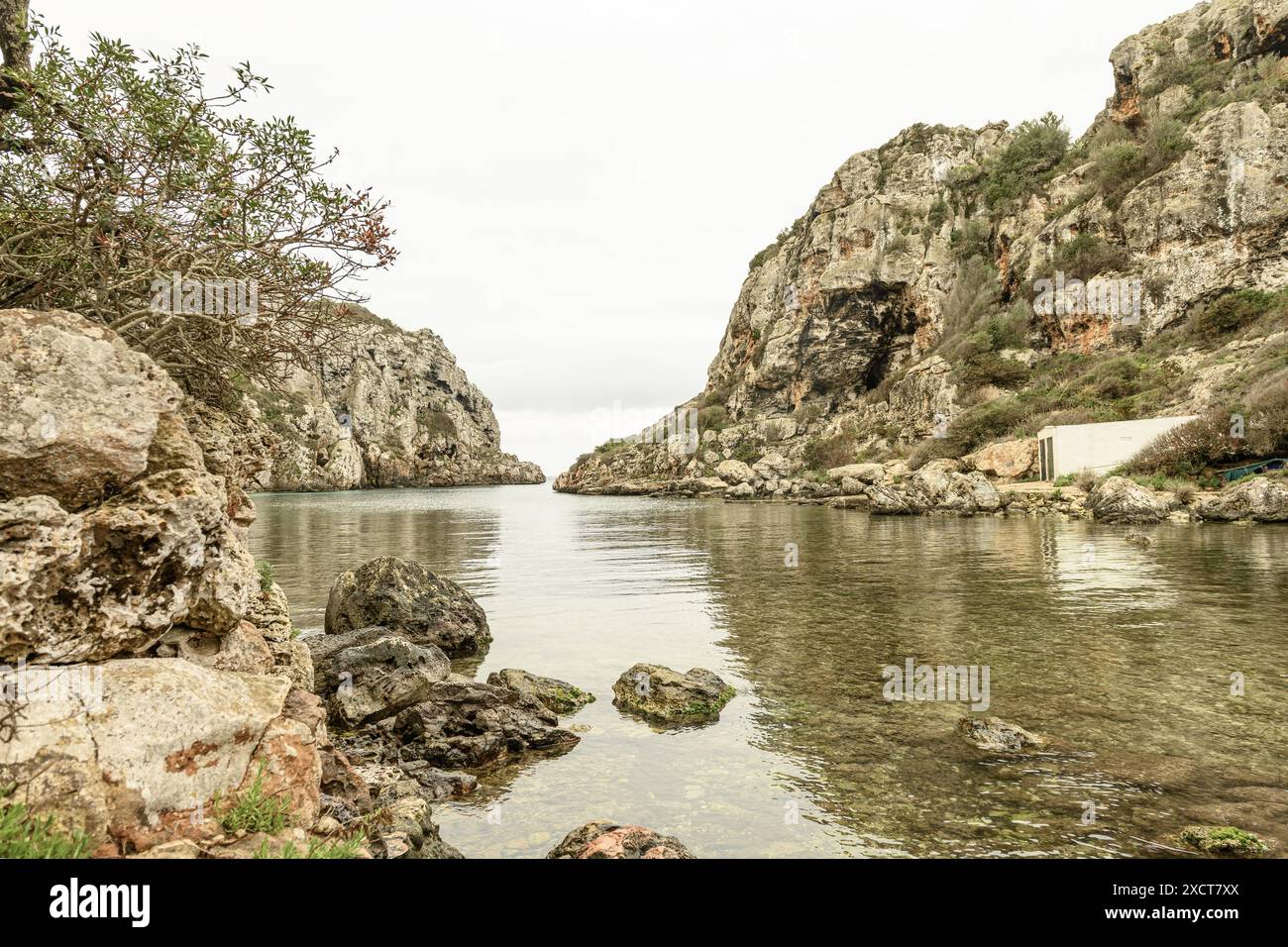 A rugged, rocky inlet at Cala Coves, Menorca, showcasing dramatic ...