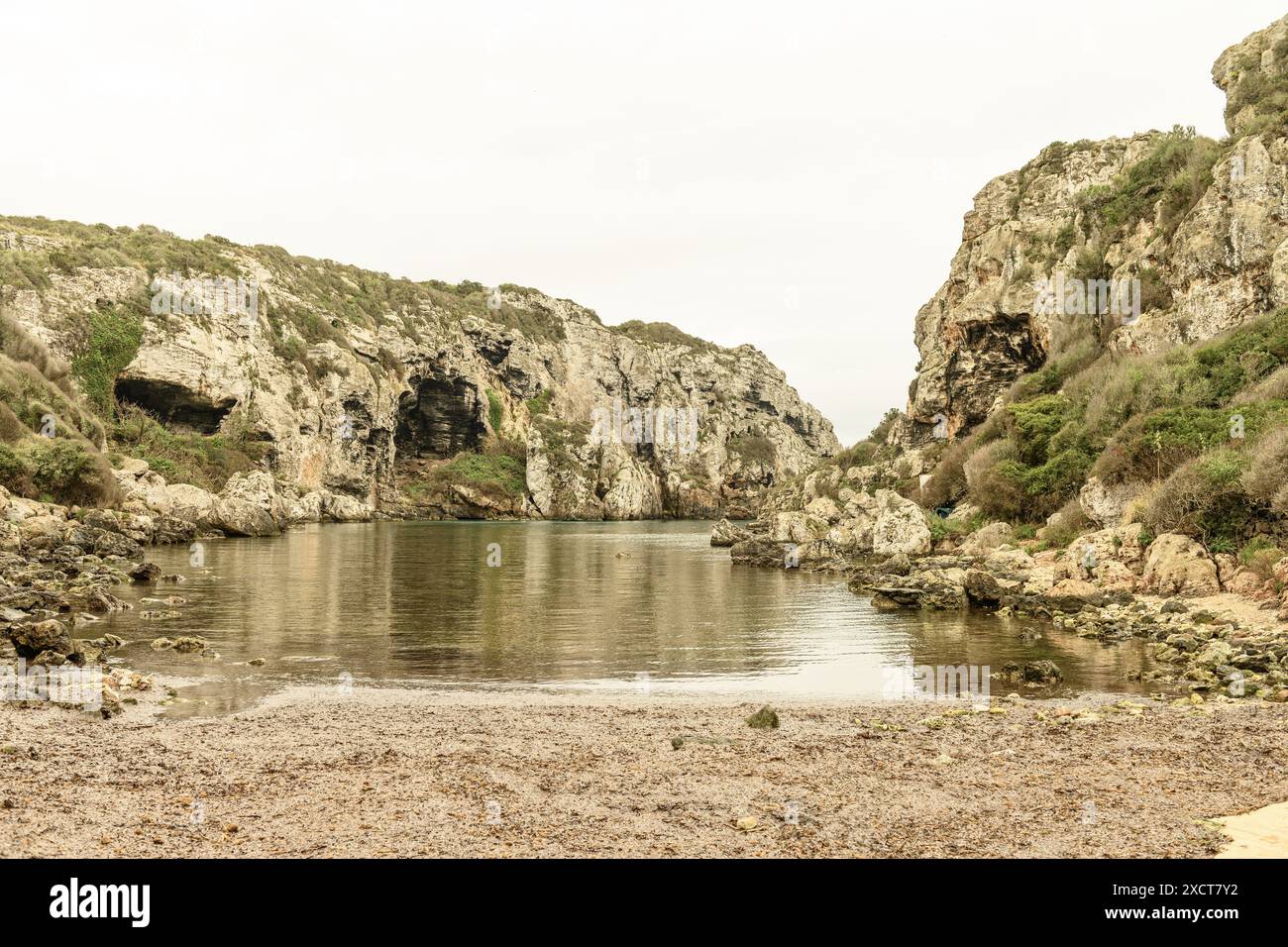 A rugged, rocky inlet at Cala Coves, Menorca, showcasing dramatic ...