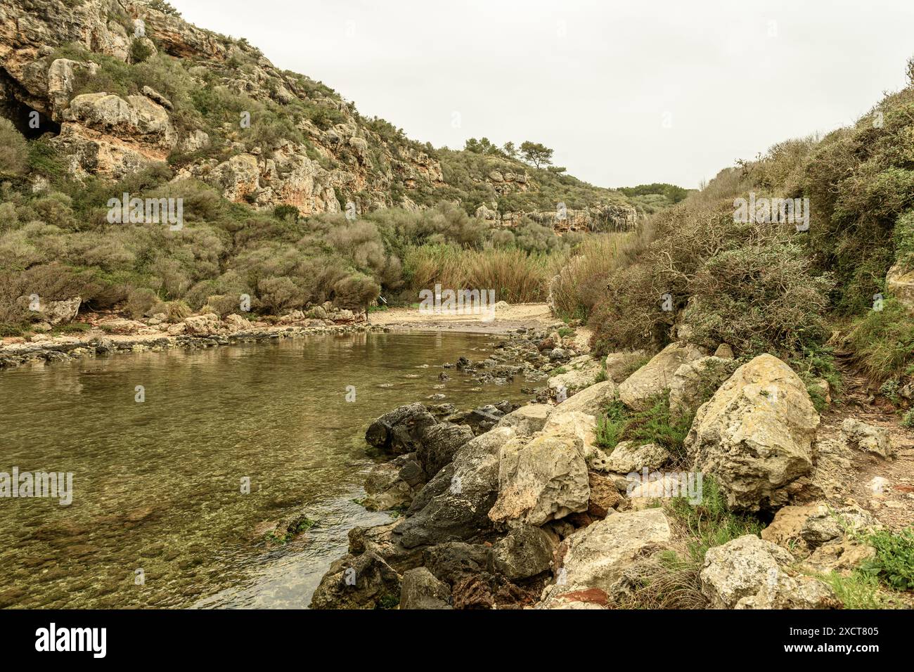 A rugged, rocky inlet at Cala Coves, Menorca, showcasing dramatic ...