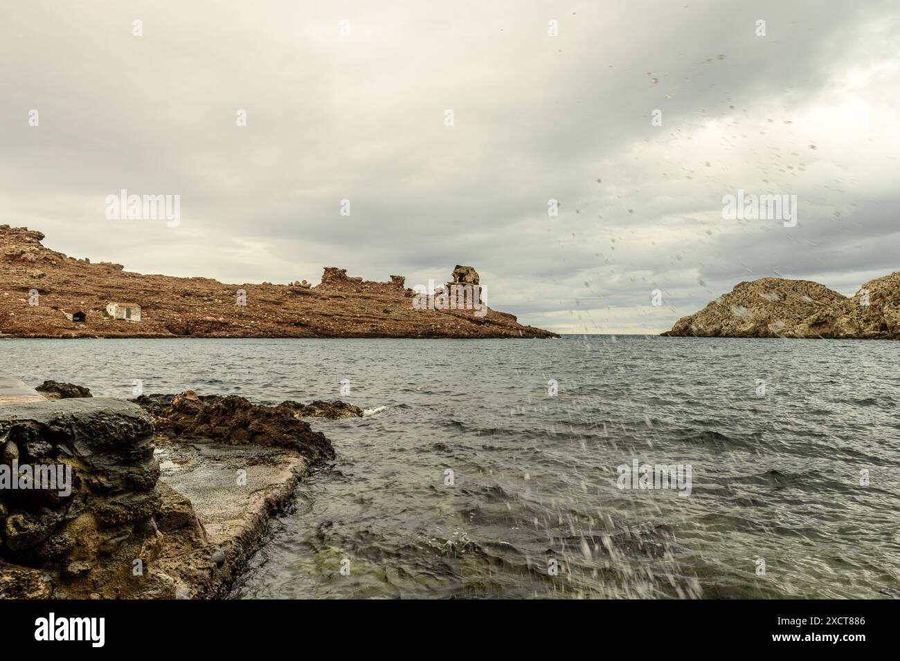 The distinctive rocky formations of Cala Morell, Menorca, under an ...