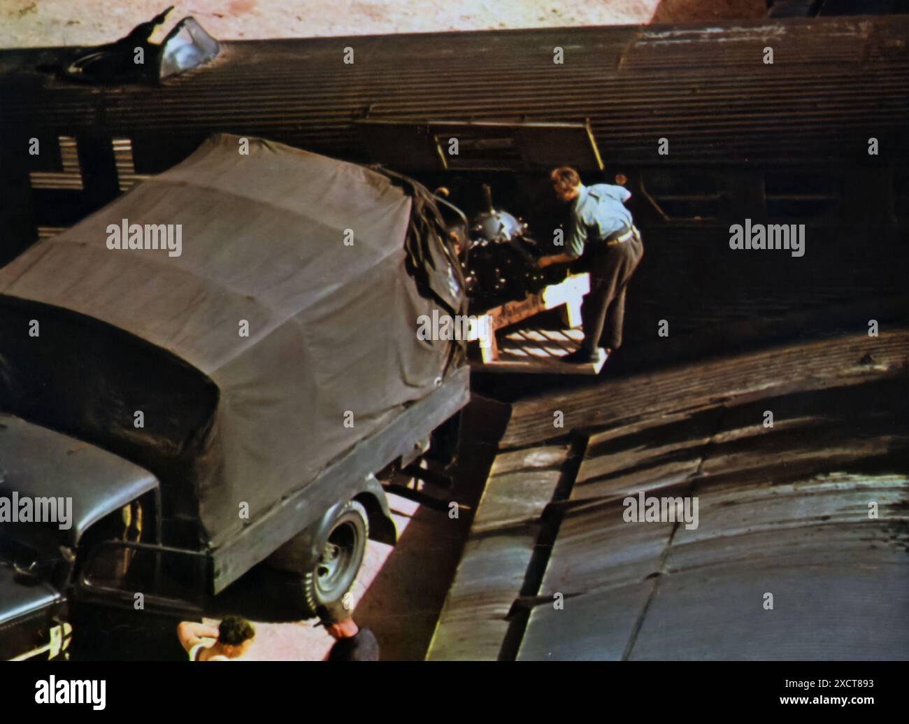 A photograph shows workmen loading an engine into a Junkers Ju 52 ...